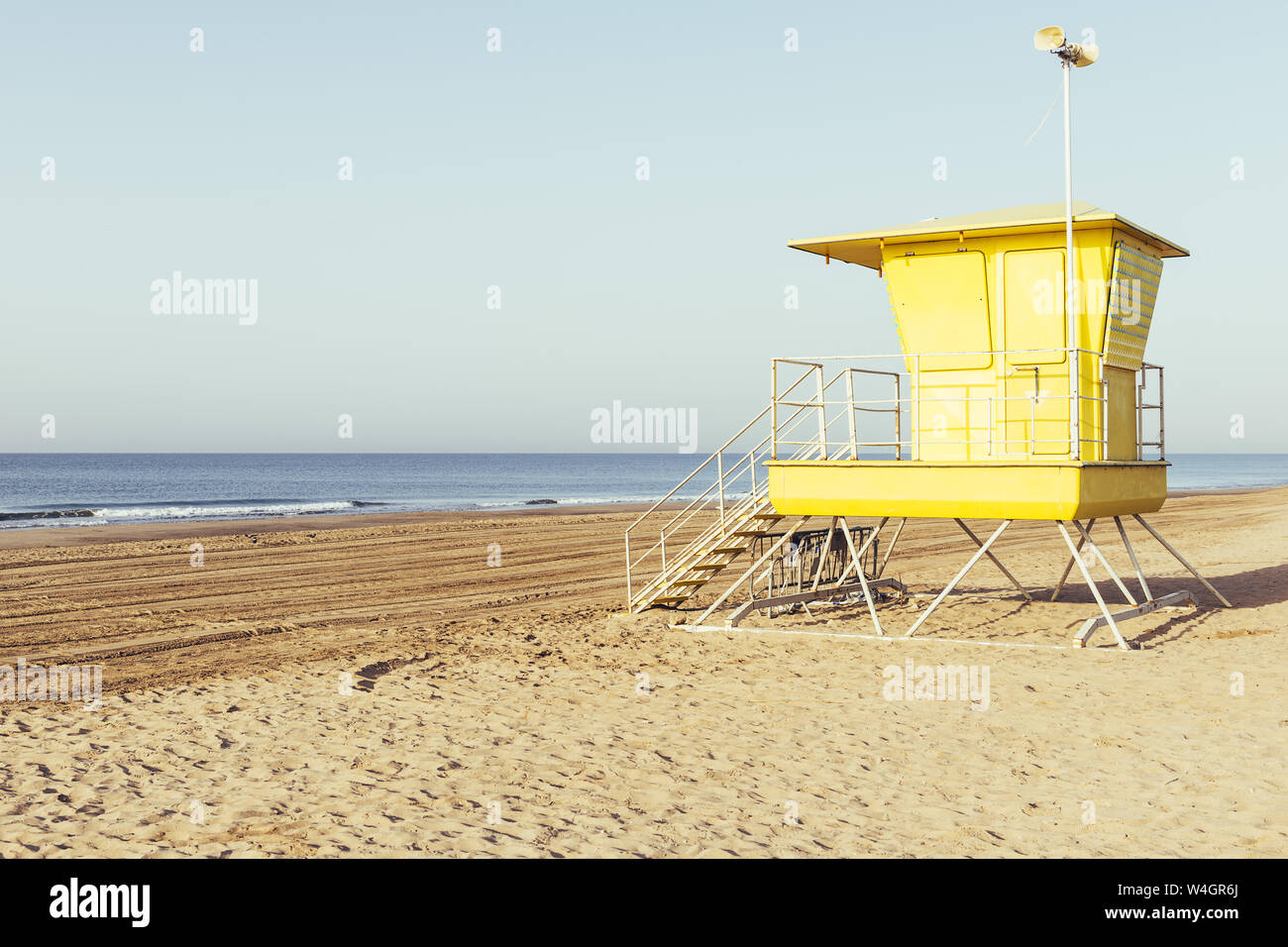 summer scene with a colorful yellow lifeguard station on the beach, at ...