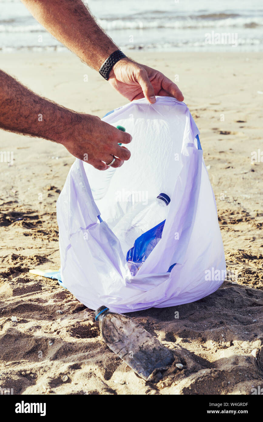 Plastic waste beach hands hi-res stock photography and images - Alamy
