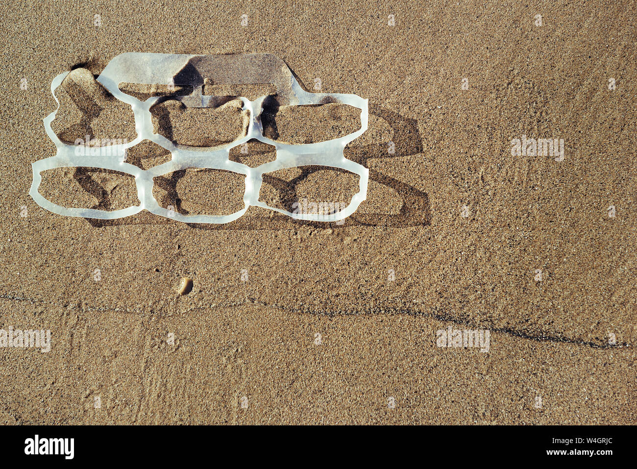background of a plastic rings lies on the sand of the beach and ...