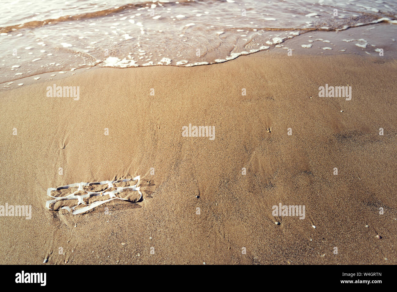 background of a plastic rings lies on the shore of the beach and ...