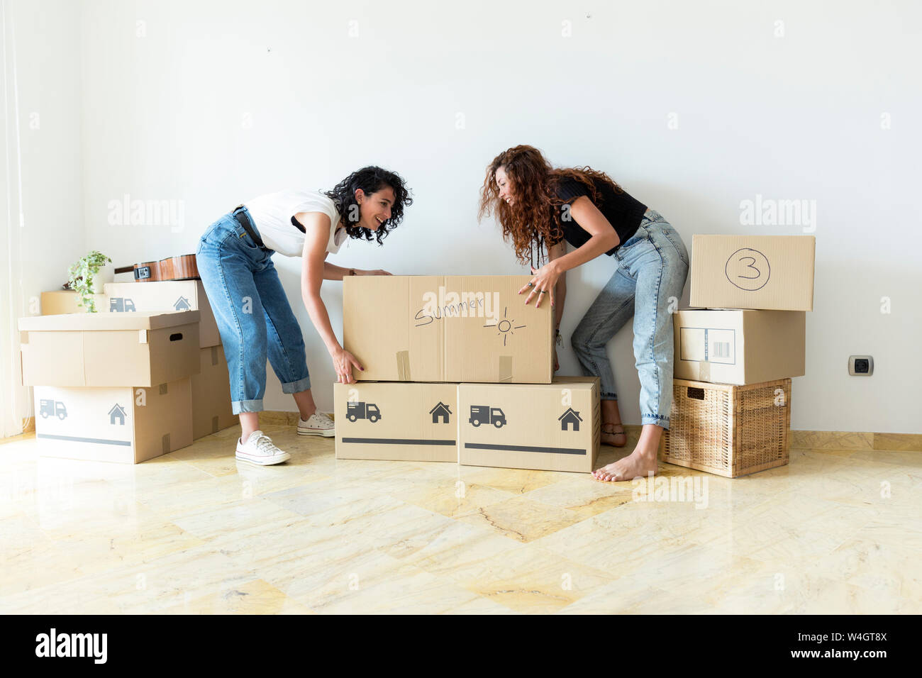 Two friends moving into new home Stock Photo - Alamy