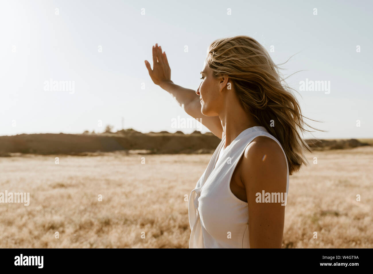 Female traveller holding hand against the sun Stock Photo - Alamy