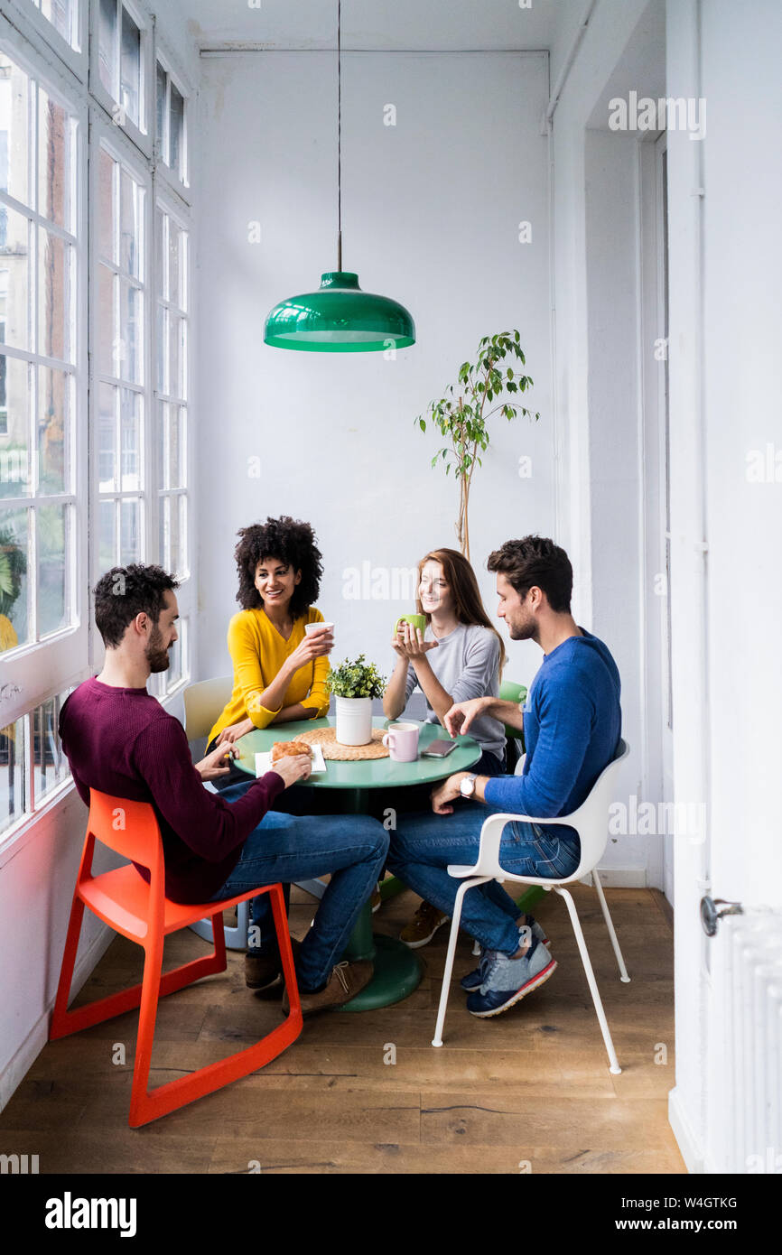 Four friends at home having coffee break Stock Photo - Alamy