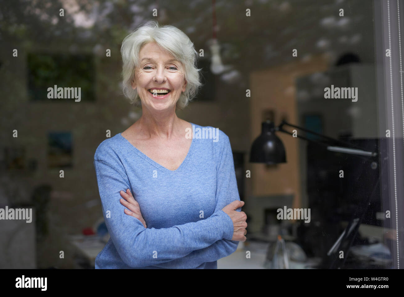 Happy mature woman by the window hi-res stock photography and images ...