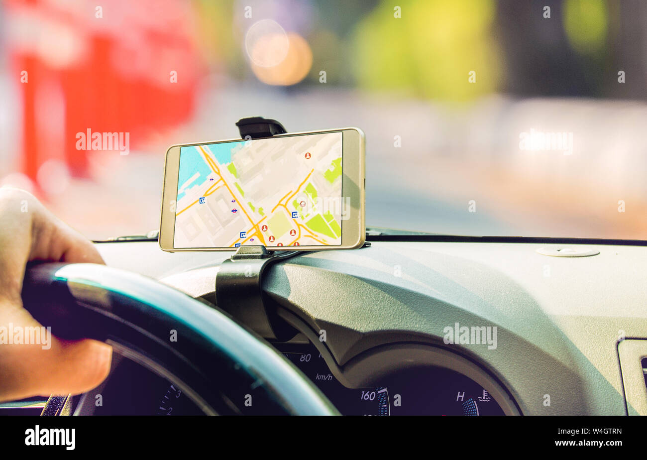 Female driver sitting in the car use mobile smart phone with map gps ...