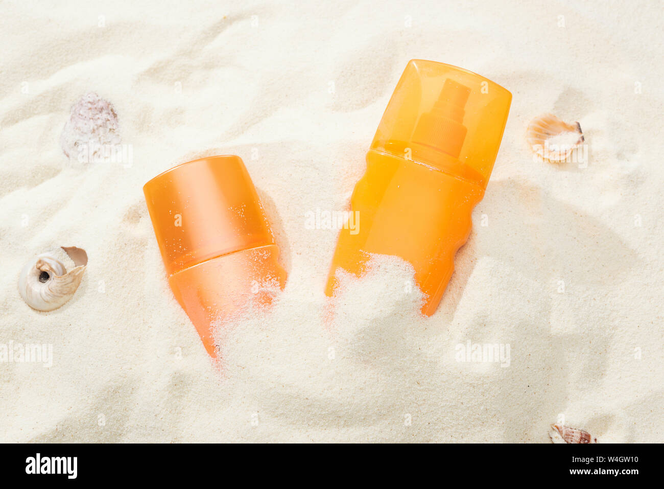 orange bottles of sunscreen in sand near seashells Stock Photo - Alamy