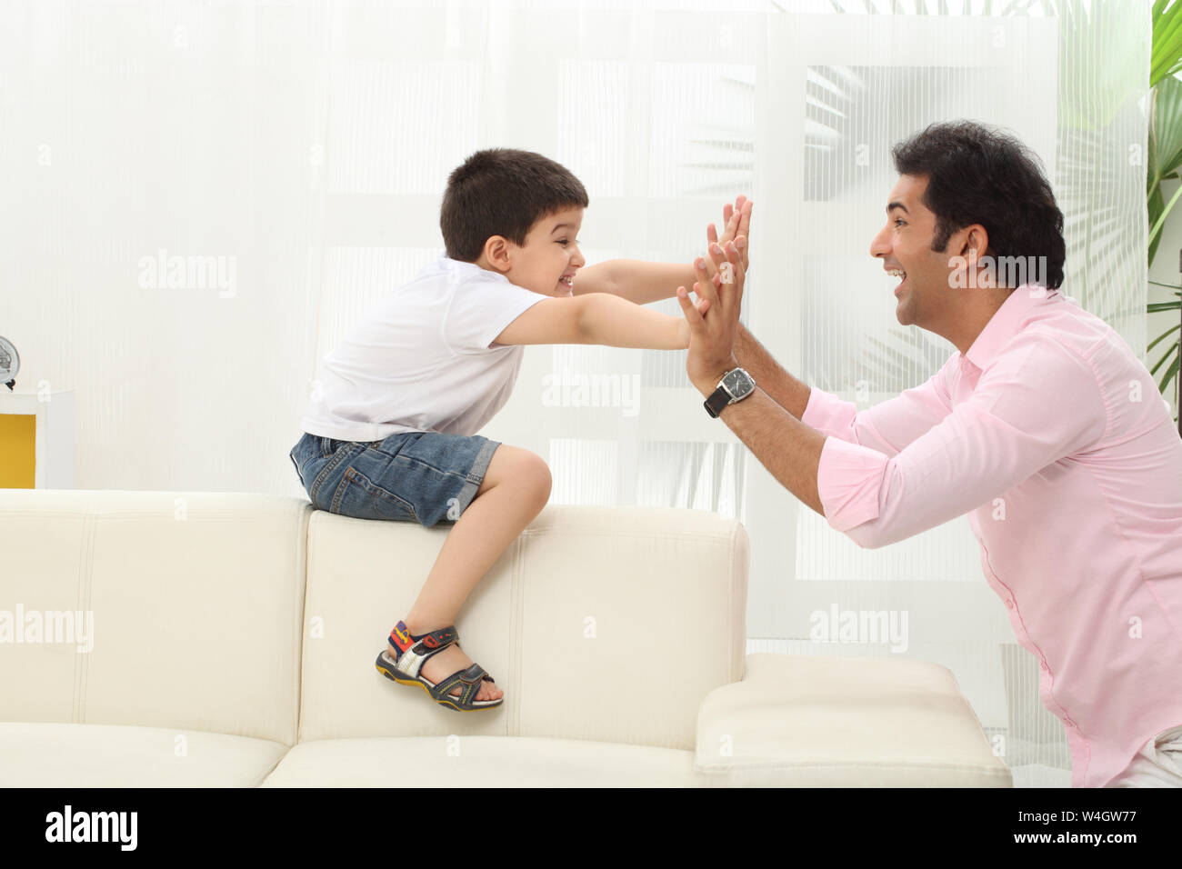 Father and son giving hi-five Stock Photo - Alamy