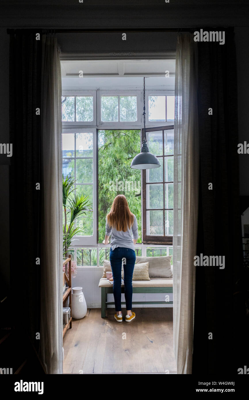 Rear view of women looking out window hi-res stock photography and ...