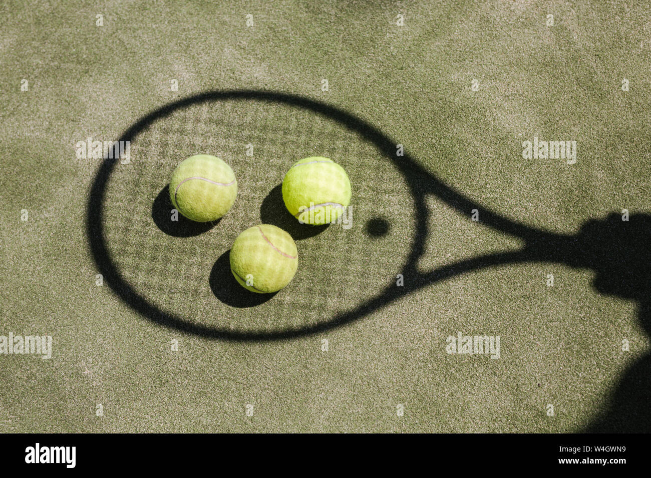 Shadow of a tennis player with balls and racket on court Stock Photo ...