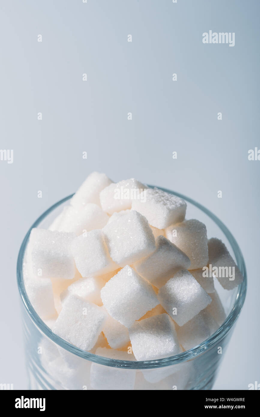 white sweet sugar cubes in glass on grey background Stock Photo - Alamy