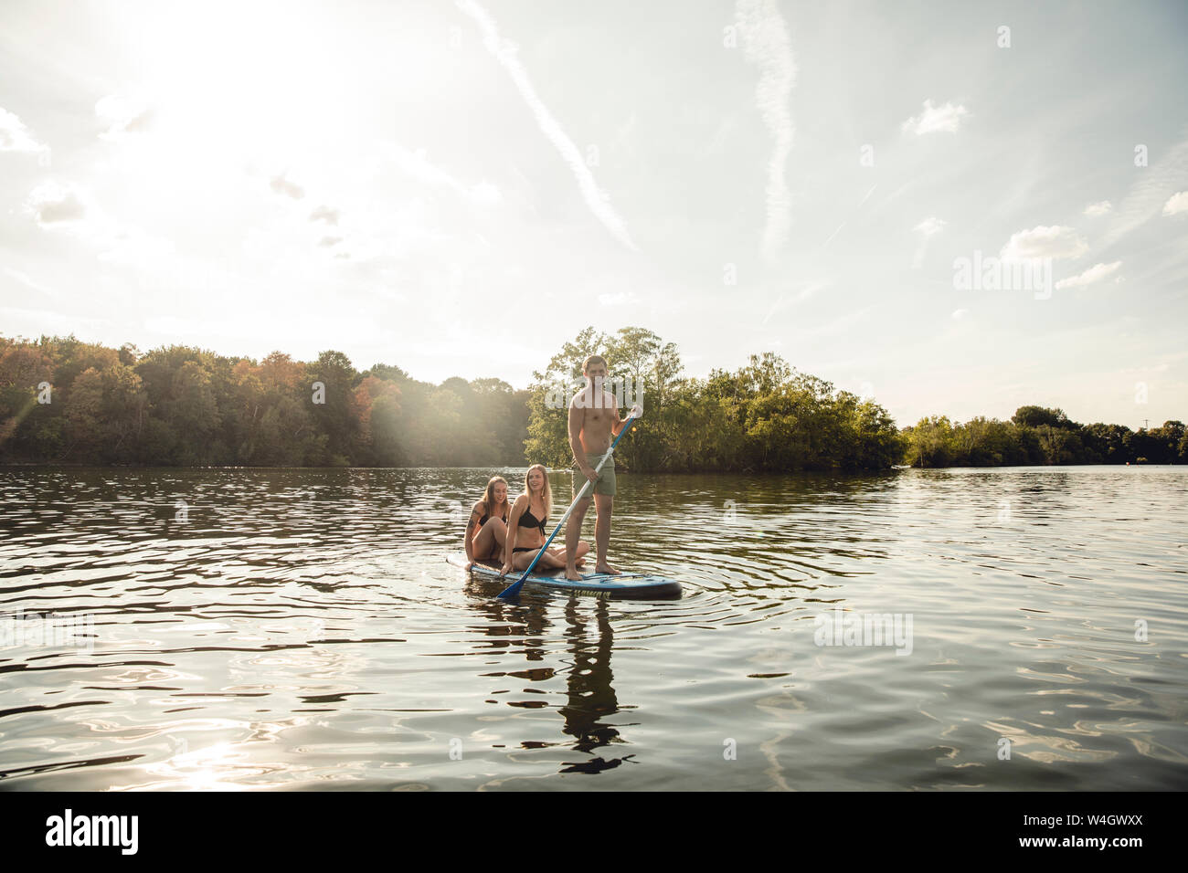 Friends enjoying summer on the lake, paddling on a paddleboard Stock ...