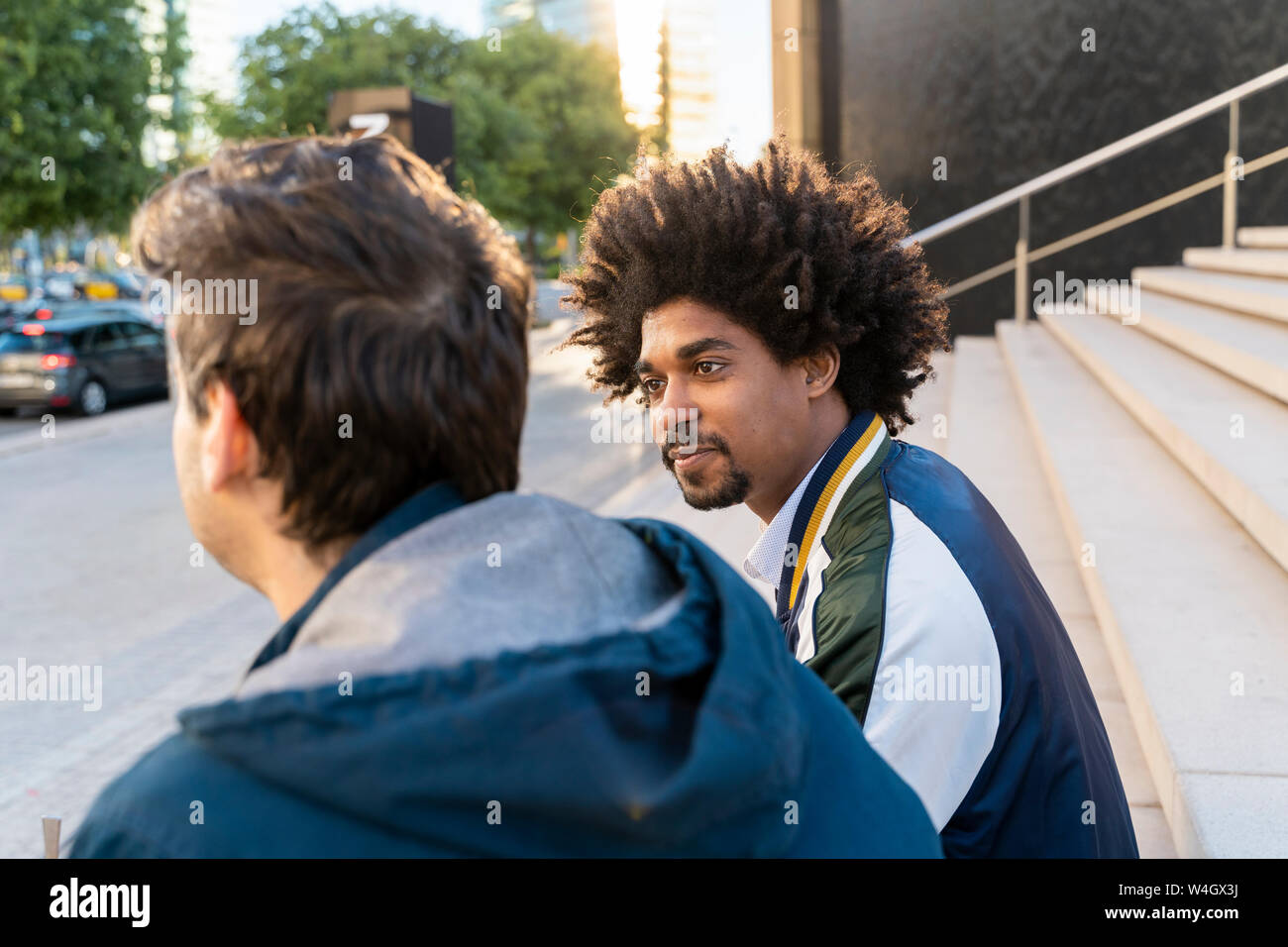 Two men sitting on stairs talking hi-res stock photography and images ...