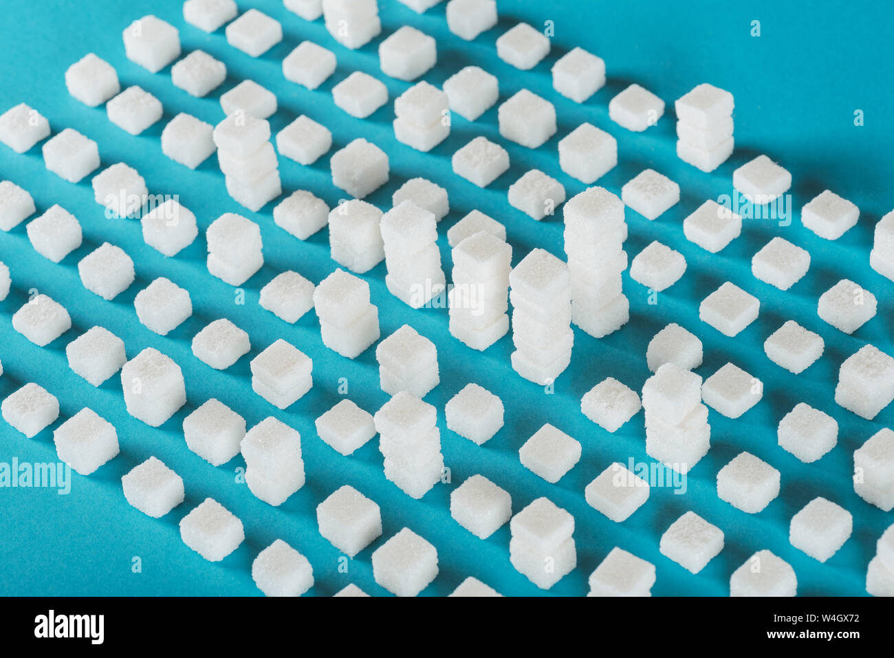 white sugar cubes arranged in rows and stacks on blue surface Stock ...