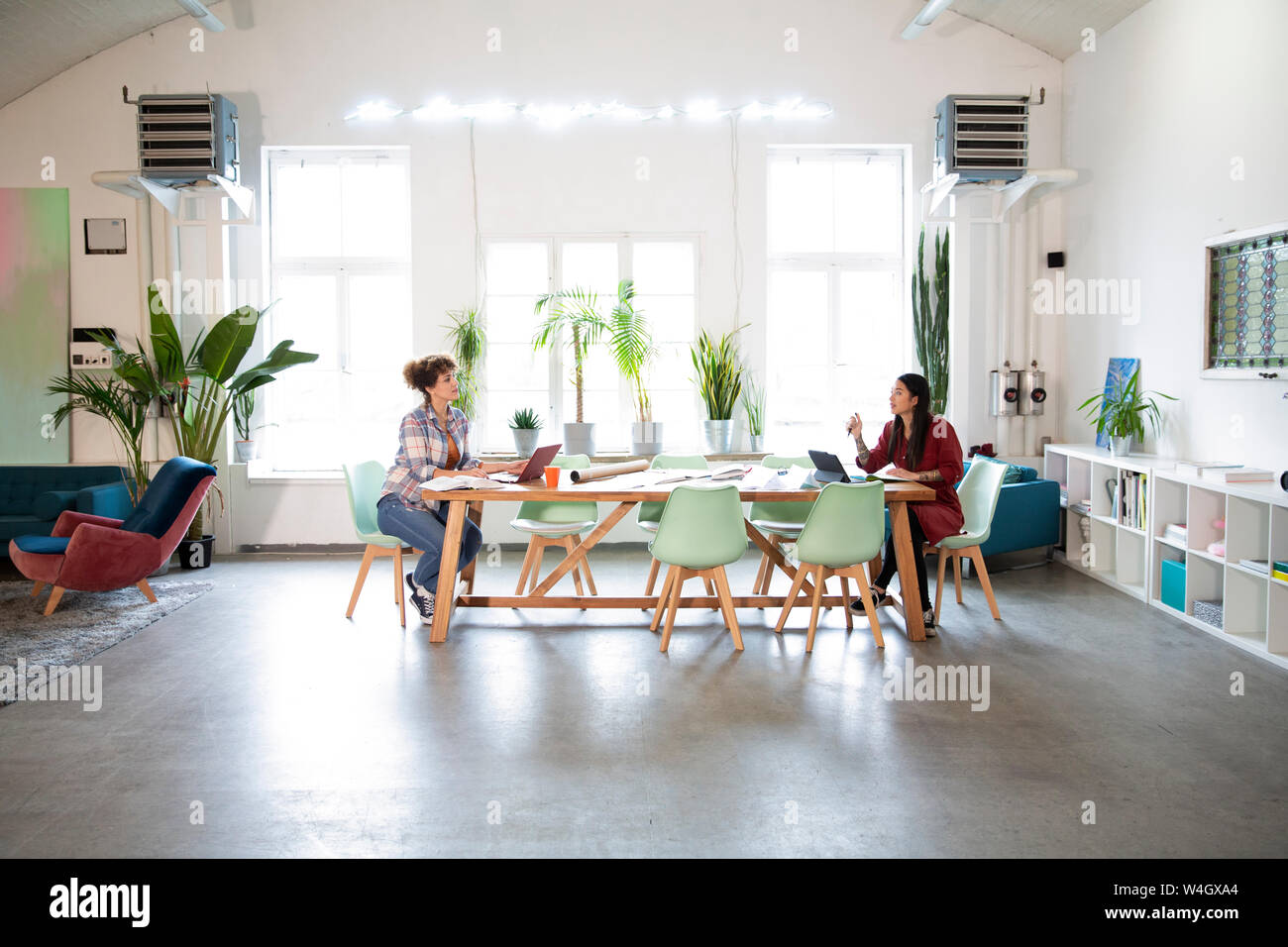 Two women working table hi-res stock photography and images - Alamy