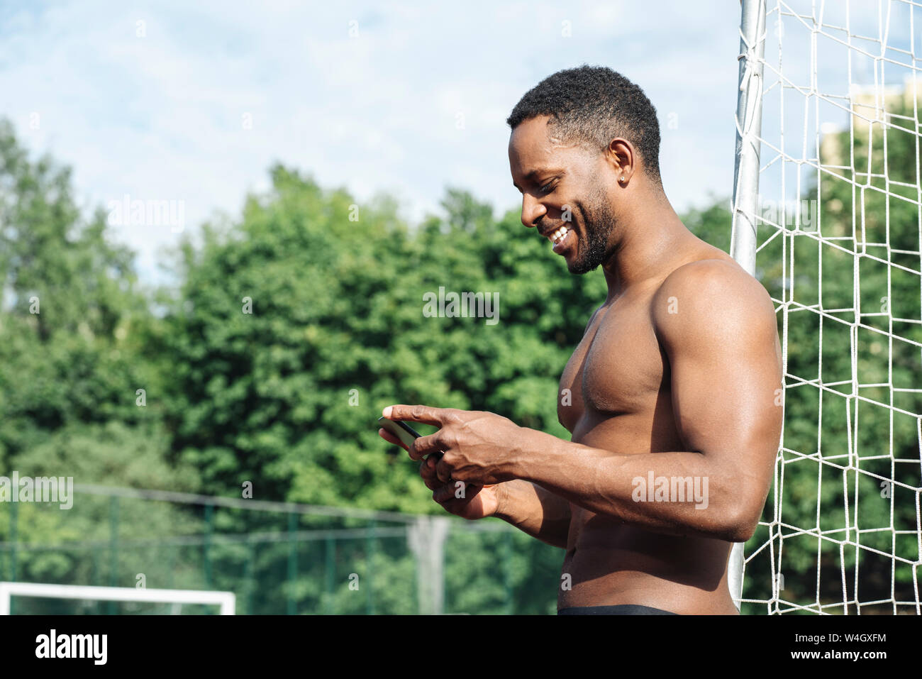 Sportsman using smartphone at soccer field Stock Photo - Alamy