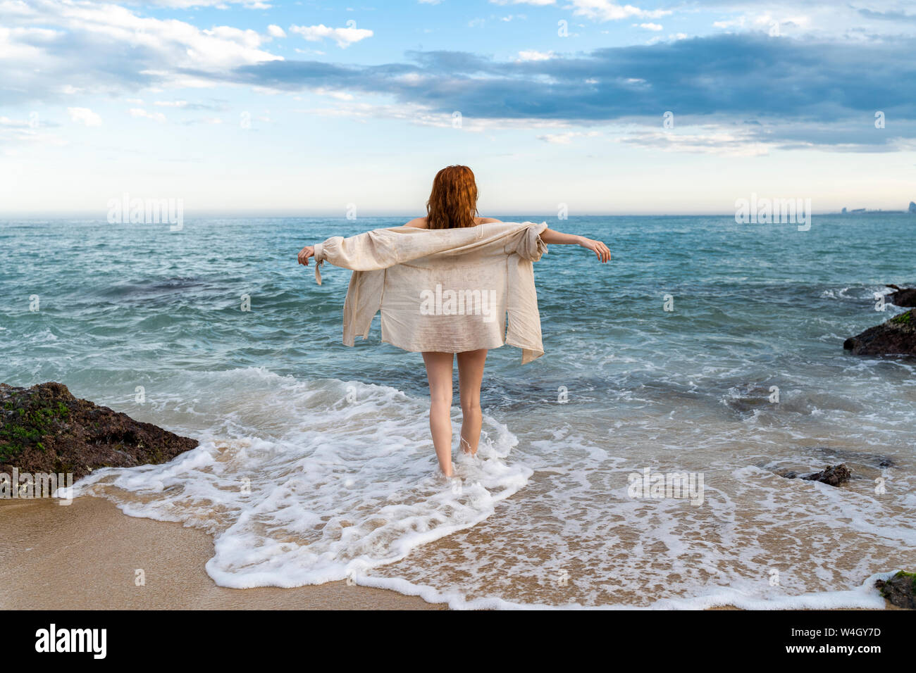 Back view of redheaded young woman at seafront Stock Photo - Alamy