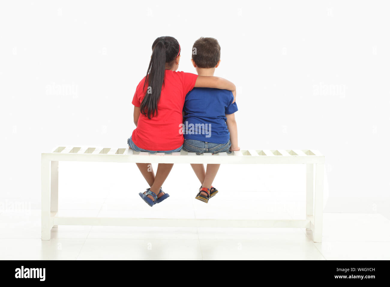 Rear view of two children sitting on a bench Stock Photo - Alamy