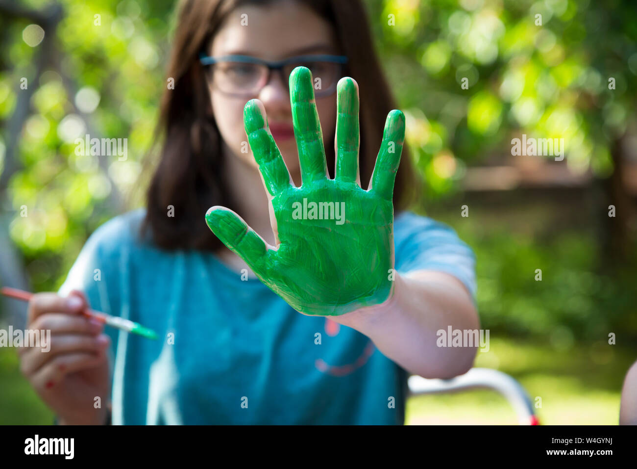 Girl's green painted hand Stock Photo - Alamy
