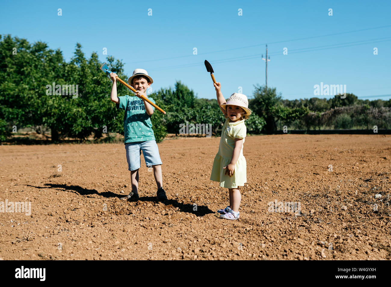 Boy and girl plowing the ground Stock Photo - Alamy