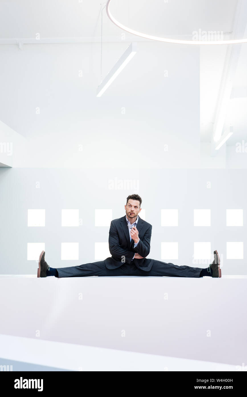 Businessman doing the splits on reception desk in office Stock Photo ...