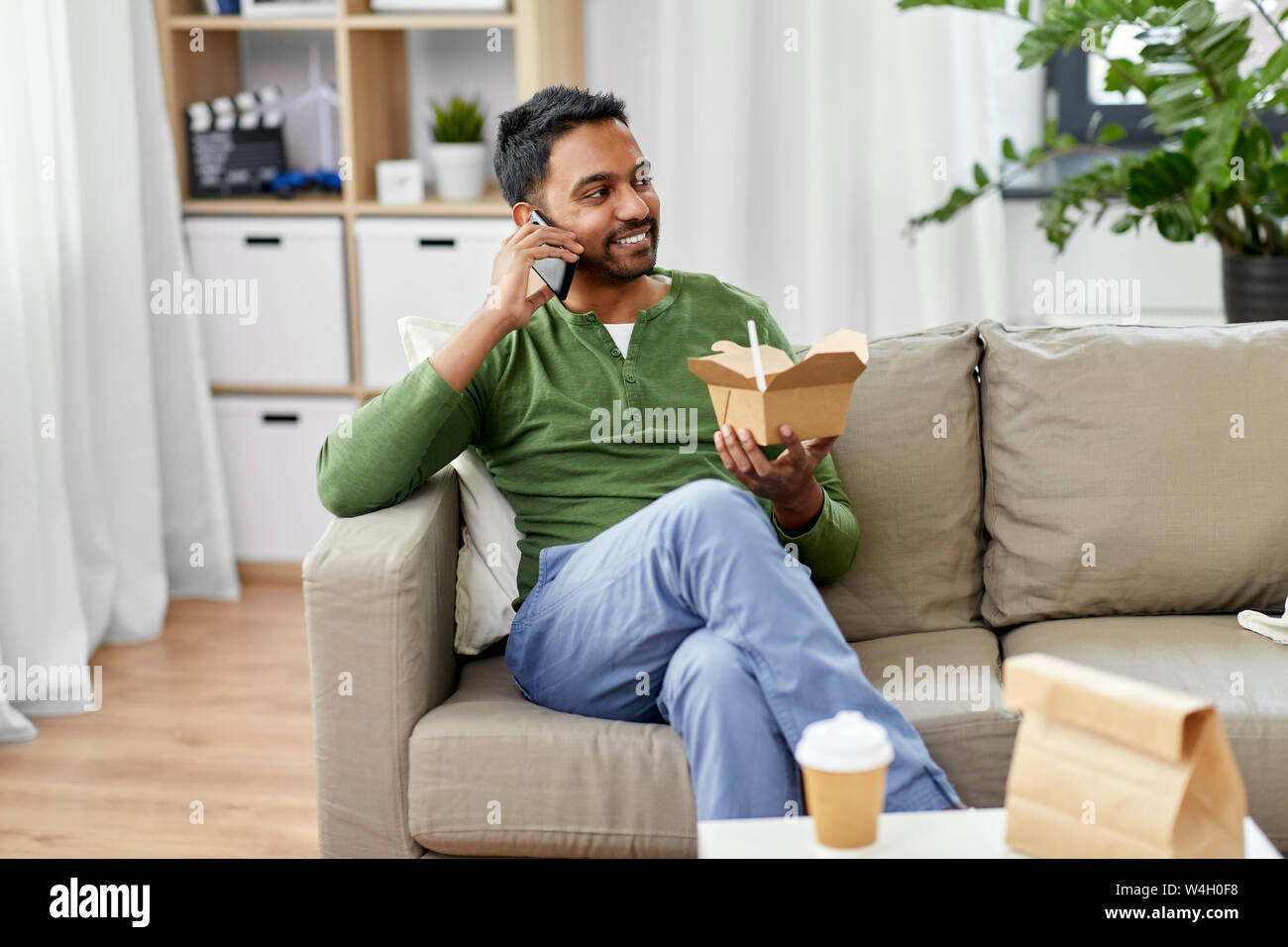 smiling indian man eating takeaway food at home Stock Photo - Alamy