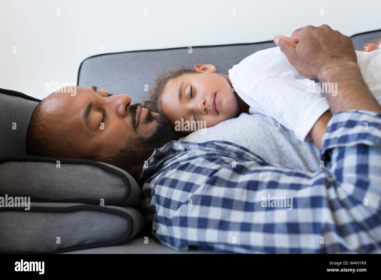 Father and daughter sleeping on couch at home Stock Photo - Alamy