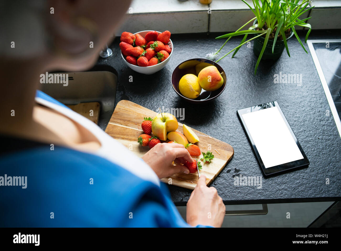 Woman chopping fruits in her kitchen, close up Stock Photo - Alamy