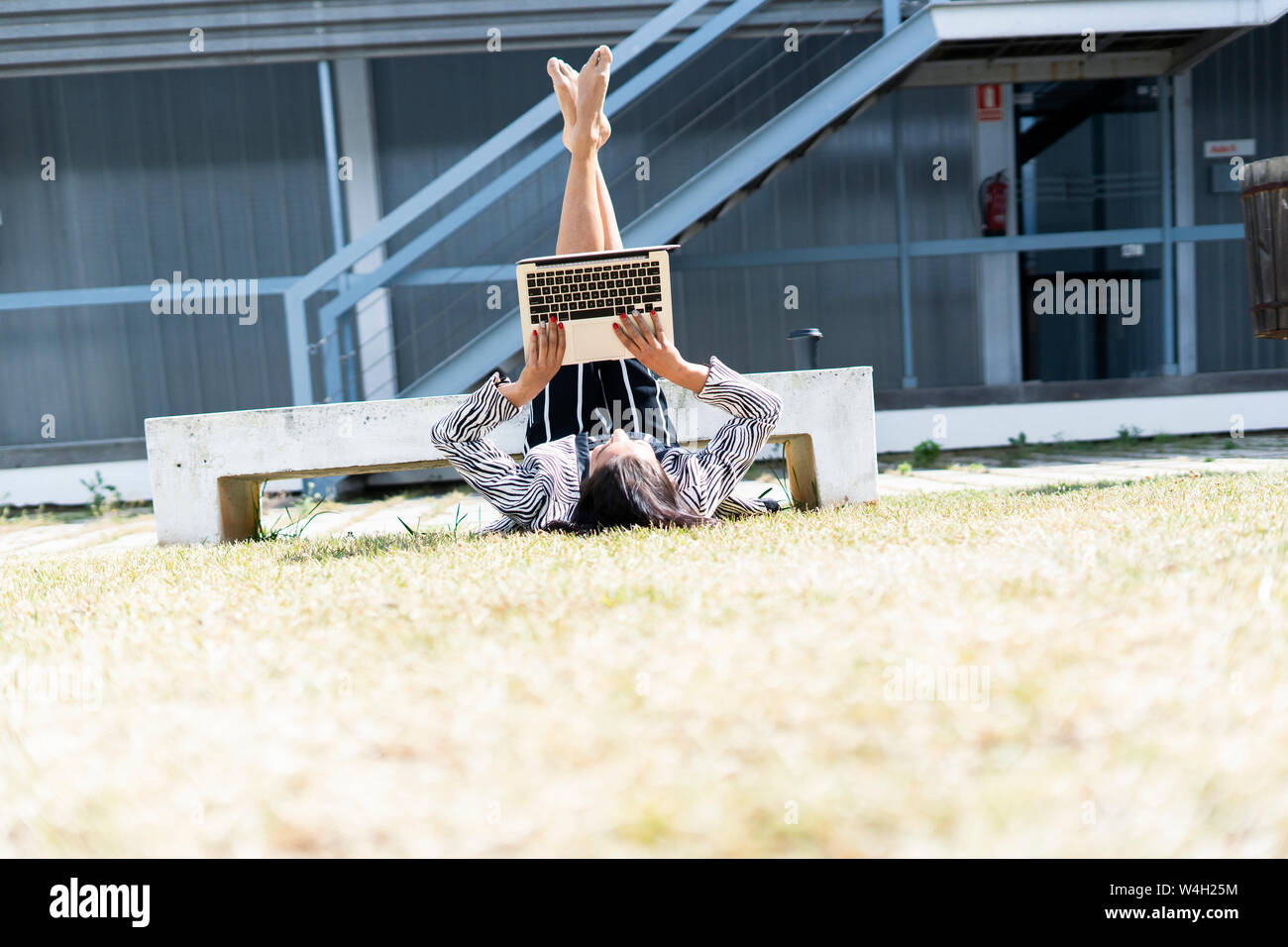 Female ballet dancer in front of an office using laptop lying Stock ...