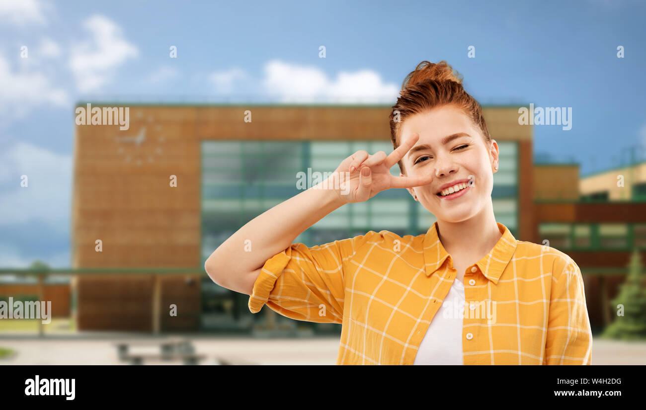 red haired teenage girl showing peace over school Stock Photo - Alamy