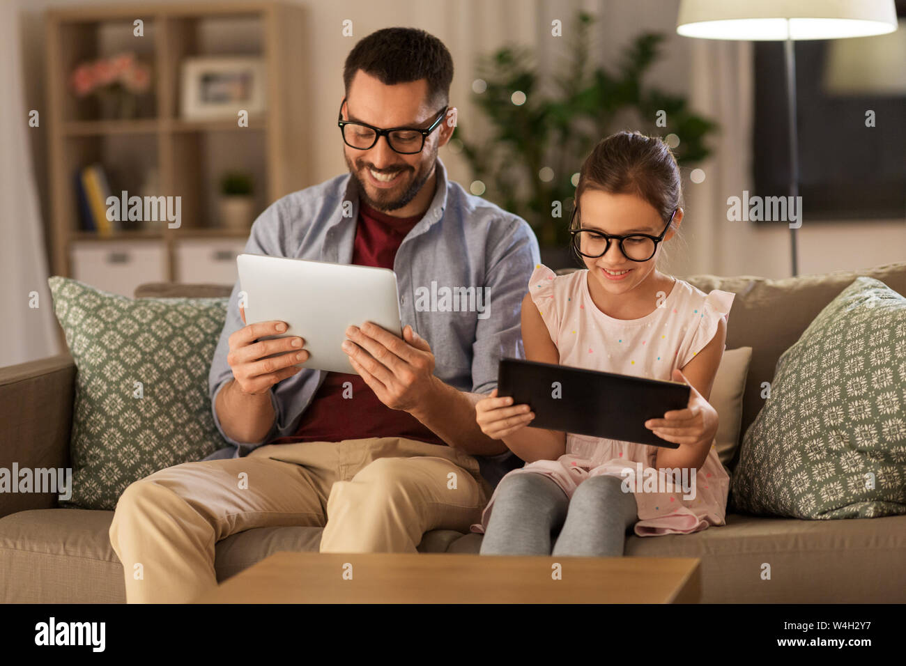 father and daughter with tablet computers at home Stock Photo - Alamy