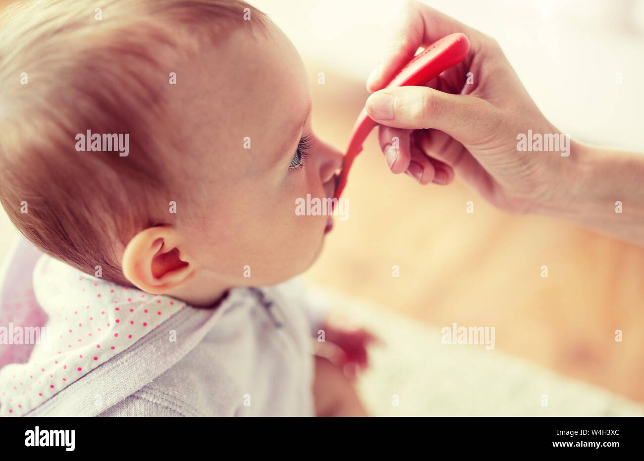 hand with spoon feeding little baby at home Stock Photo - Alamy