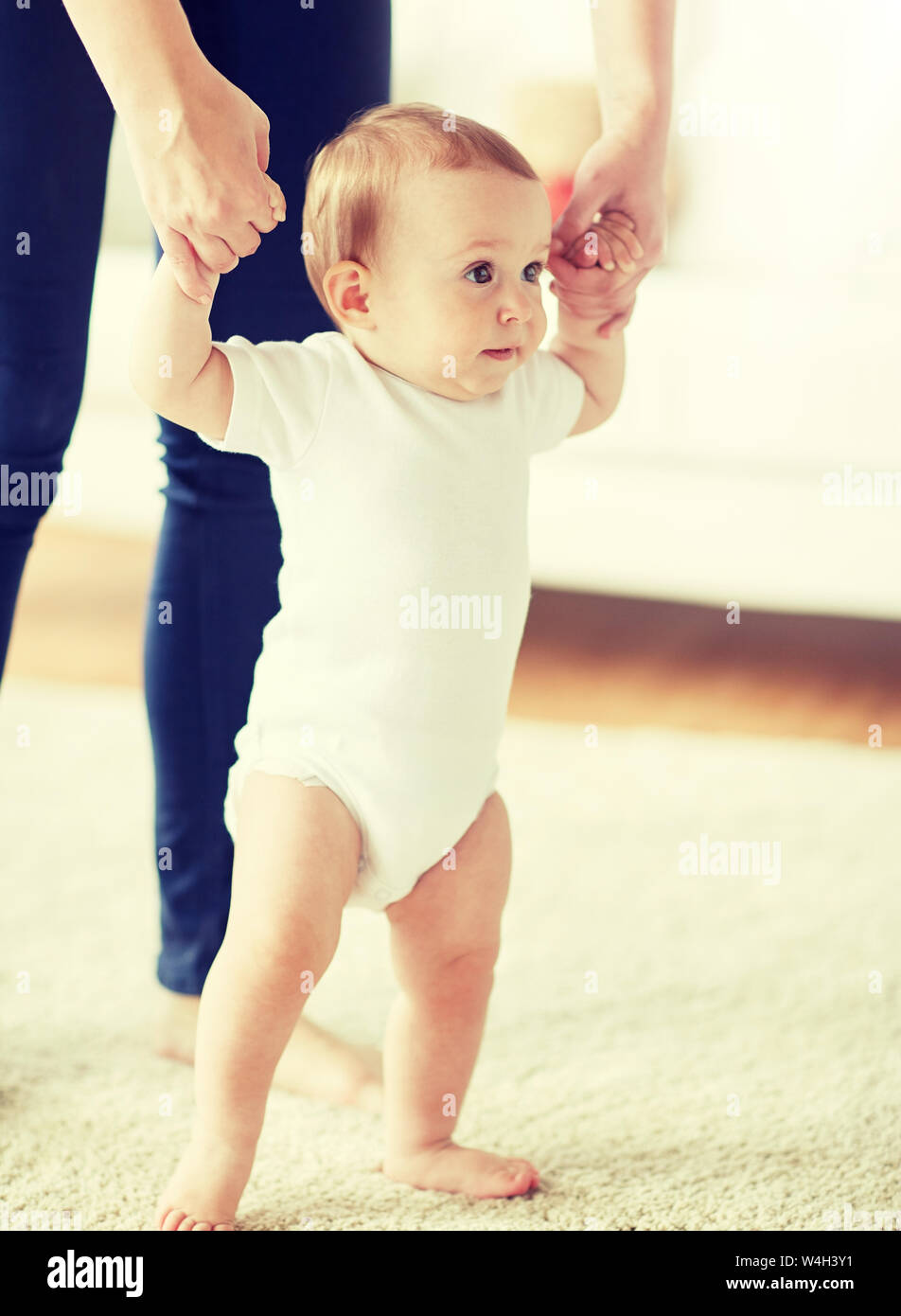 happy baby learning to walk with mother help Stock Photo - Alamy