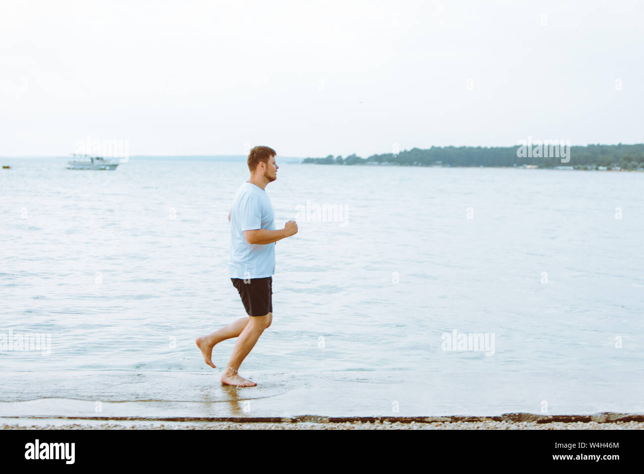 Man barefoot running beach handsome hi-res stock photography and images ...
