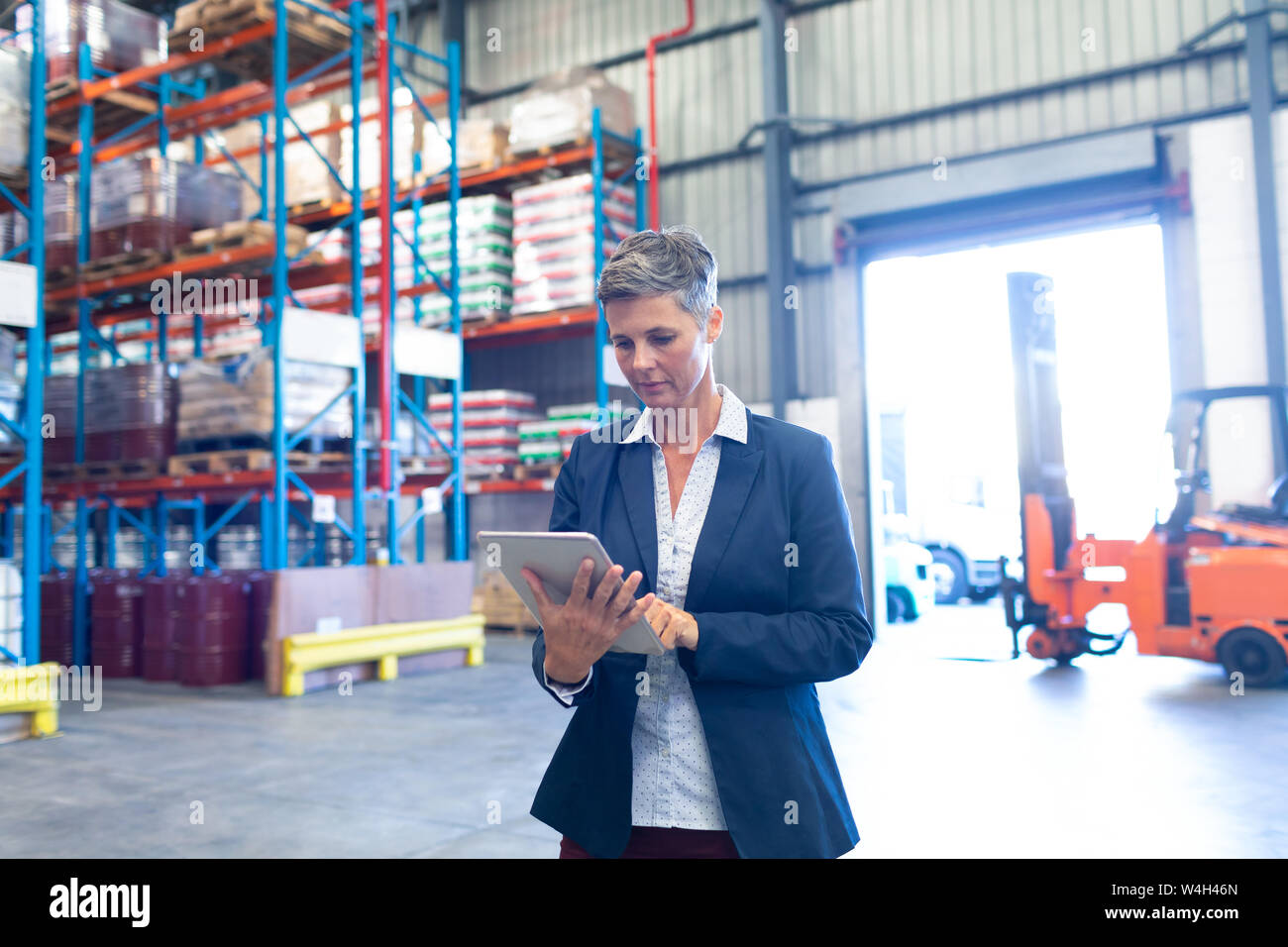 Female manager using digital tablet in warehouse Stock Photo - Alamy