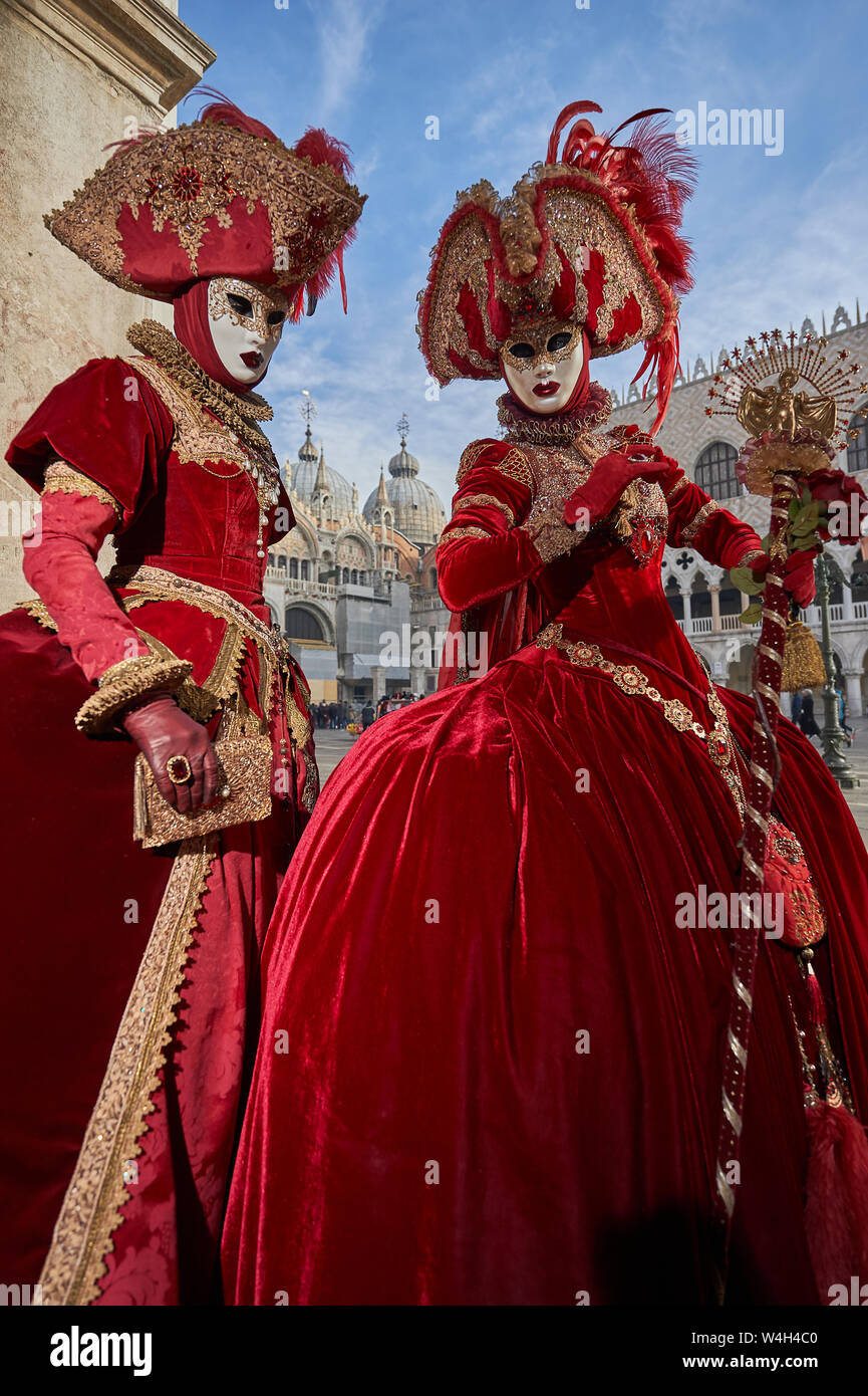 Venetian Masks in red costumes in Venice Italy Stock Photo - Alamy