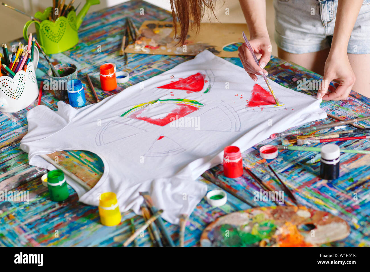 Drawing on clothes. Girl draws on a white T-shirt Stock Photo - Alamy