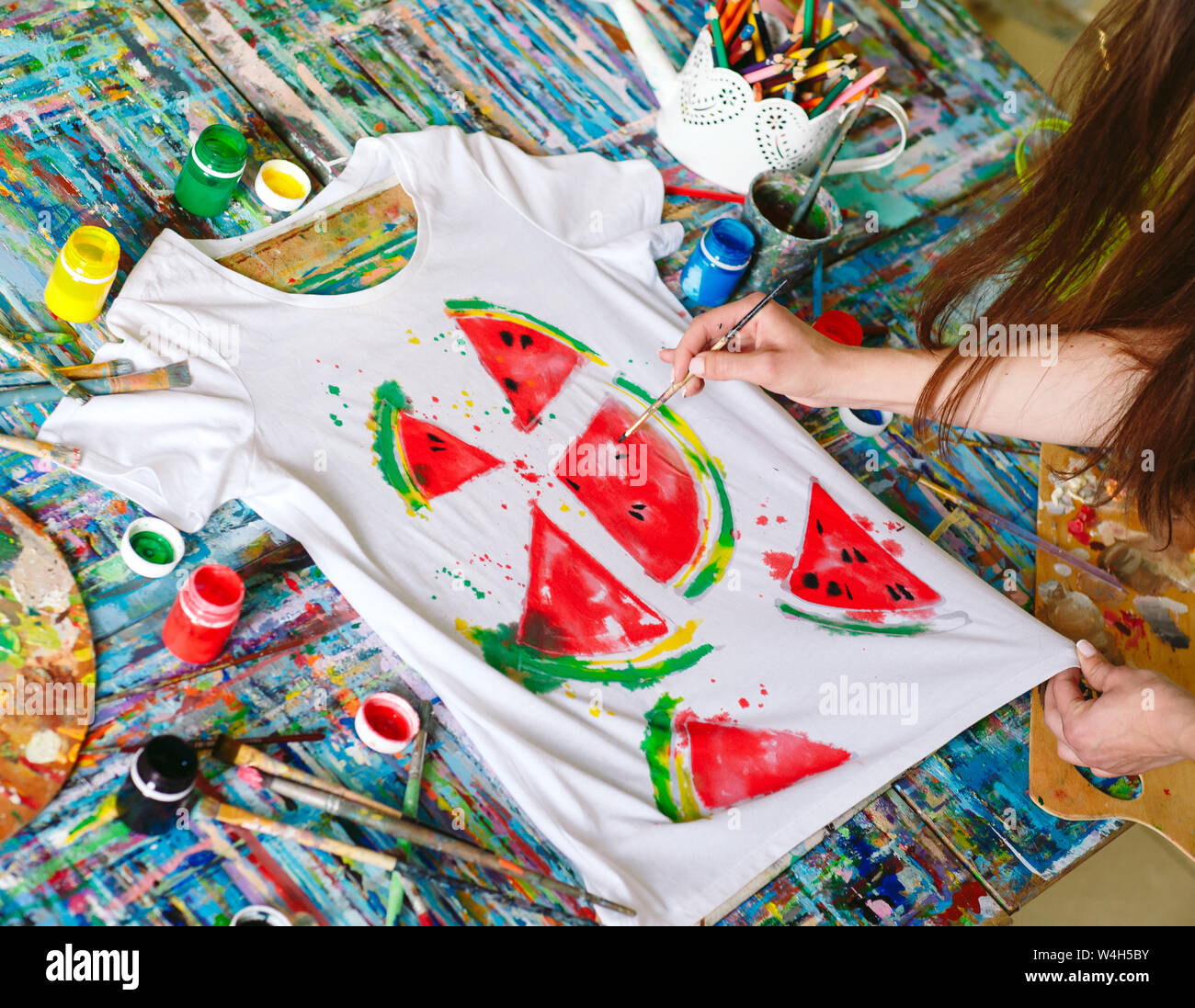 Drawing on clothes. Girl draws on a white T-shirt Stock Photo - Alamy