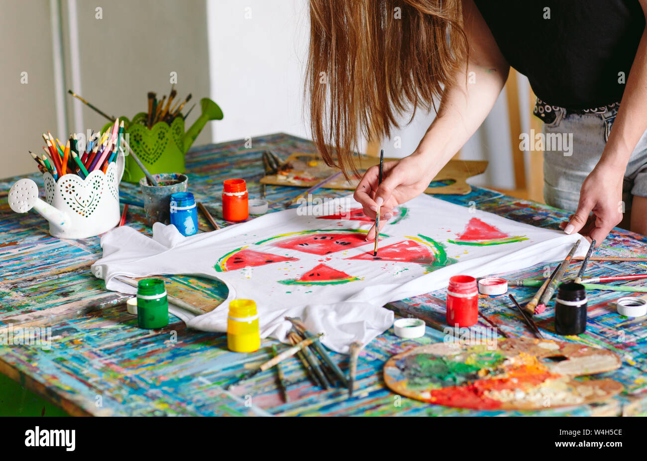 Drawing on clothes. Girl draws on a white T-shirt Stock Photo - Alamy