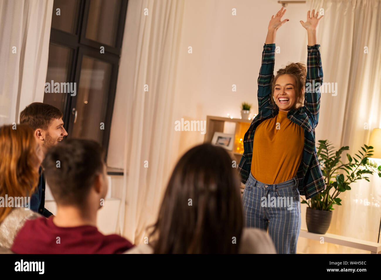 happy friends playing charades at home in evening Stock Photo - Alamy
