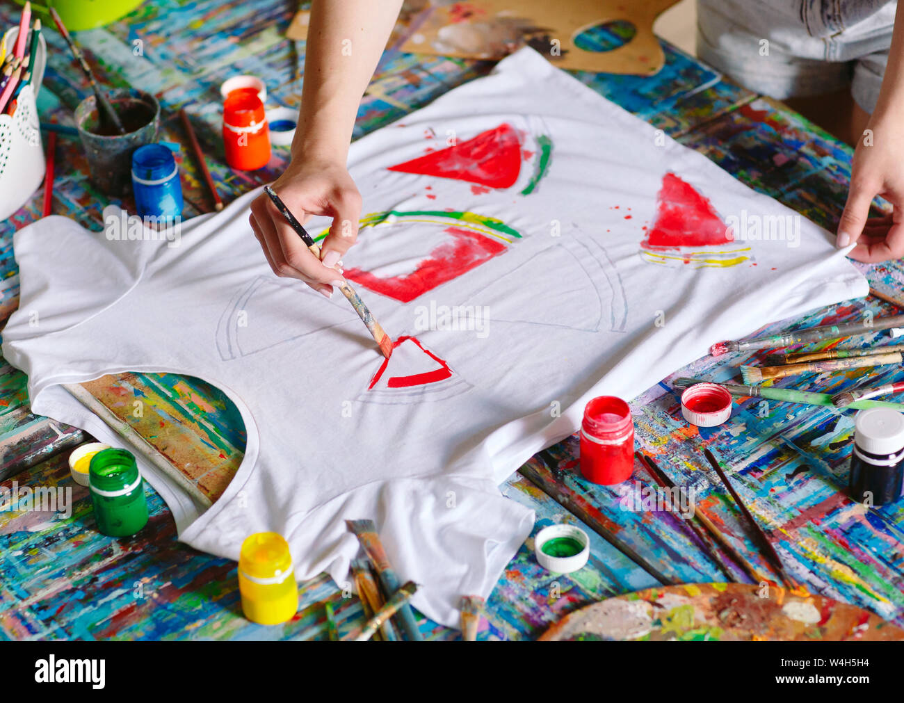 Drawing on clothes. Girl draws on a white T-shirt Stock Photo - Alamy