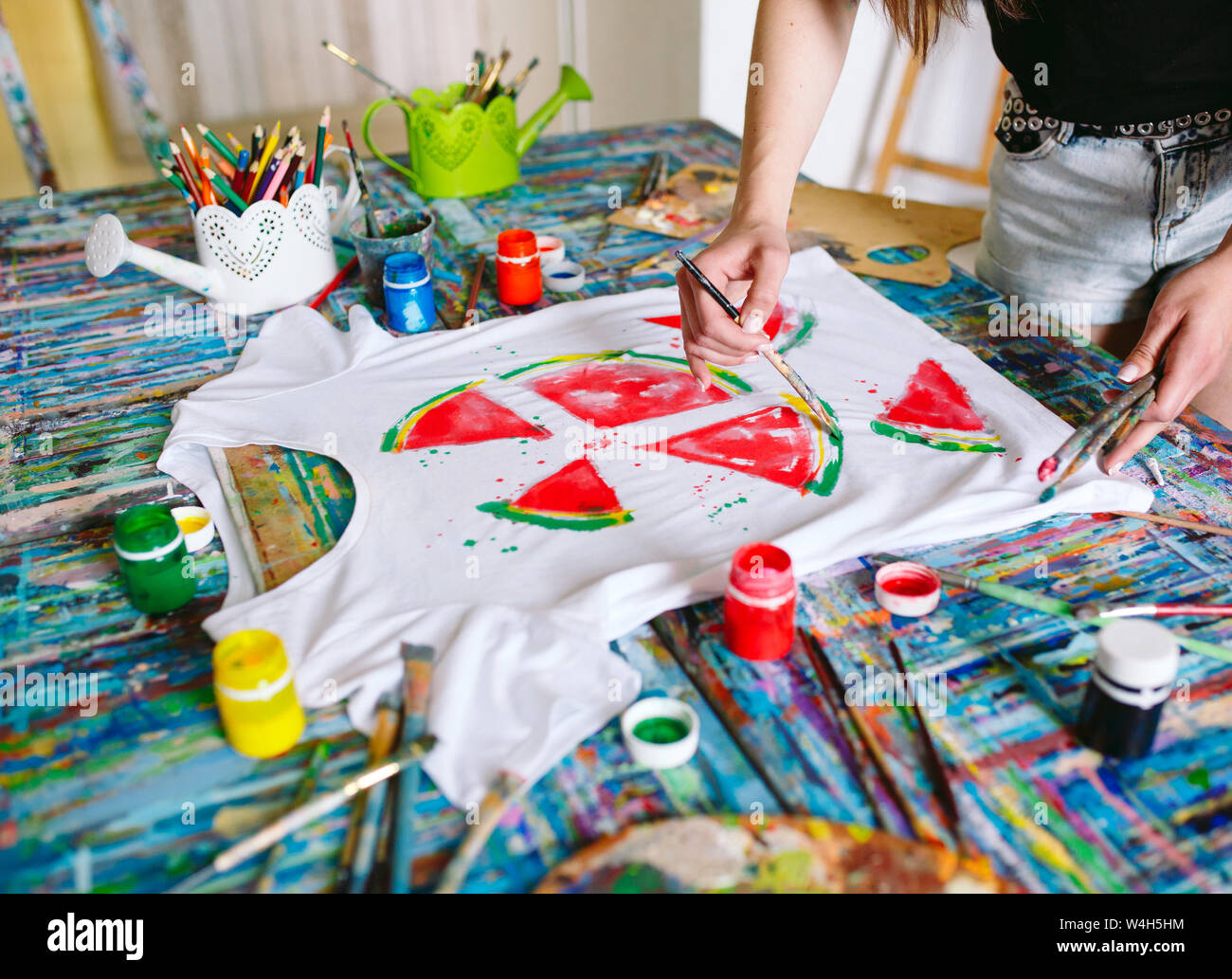Drawing on clothes. Girl draws on a white T-shirt Stock Photo - Alamy