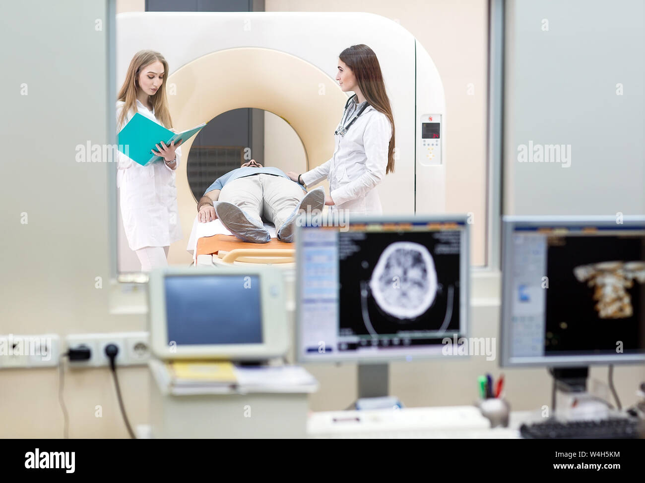 MRI machine and screens with doctor and nurse Stock Photo - Alamy