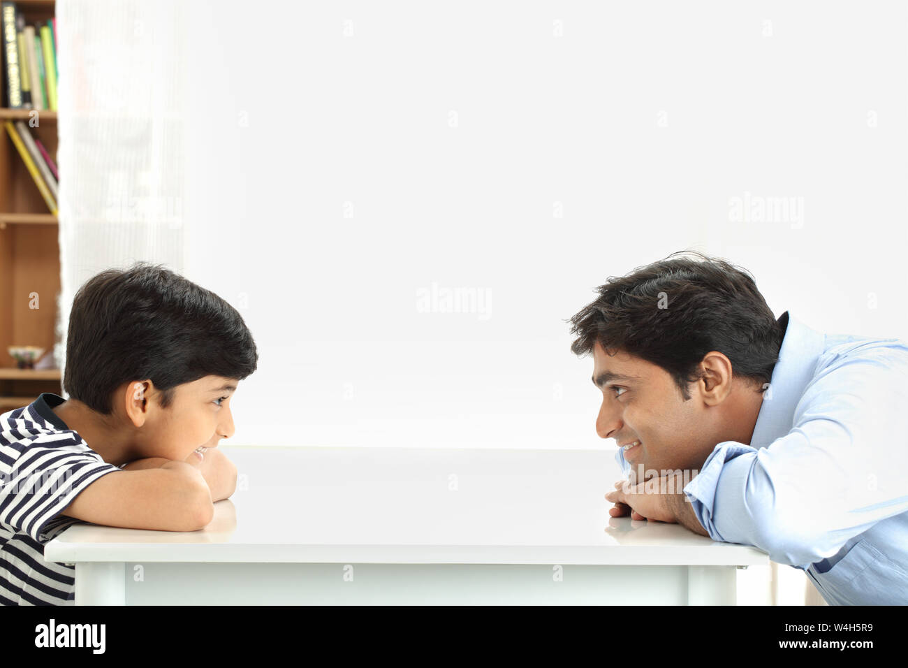 Man and sonplaying eye contact game and smiling Stock Photo - Alamy