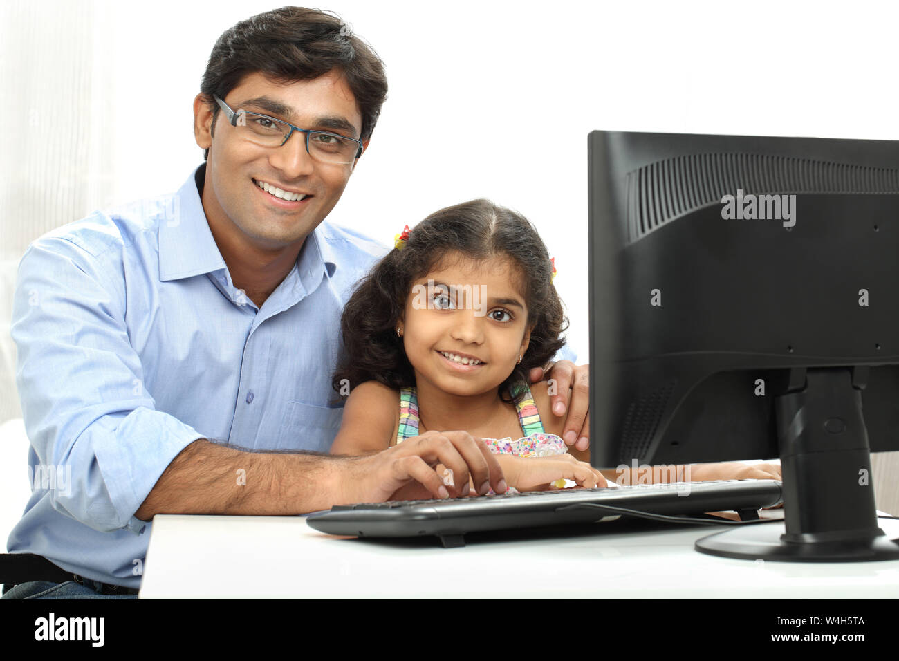 Man with his daughter using a computer at home Stock Photo - Alamy