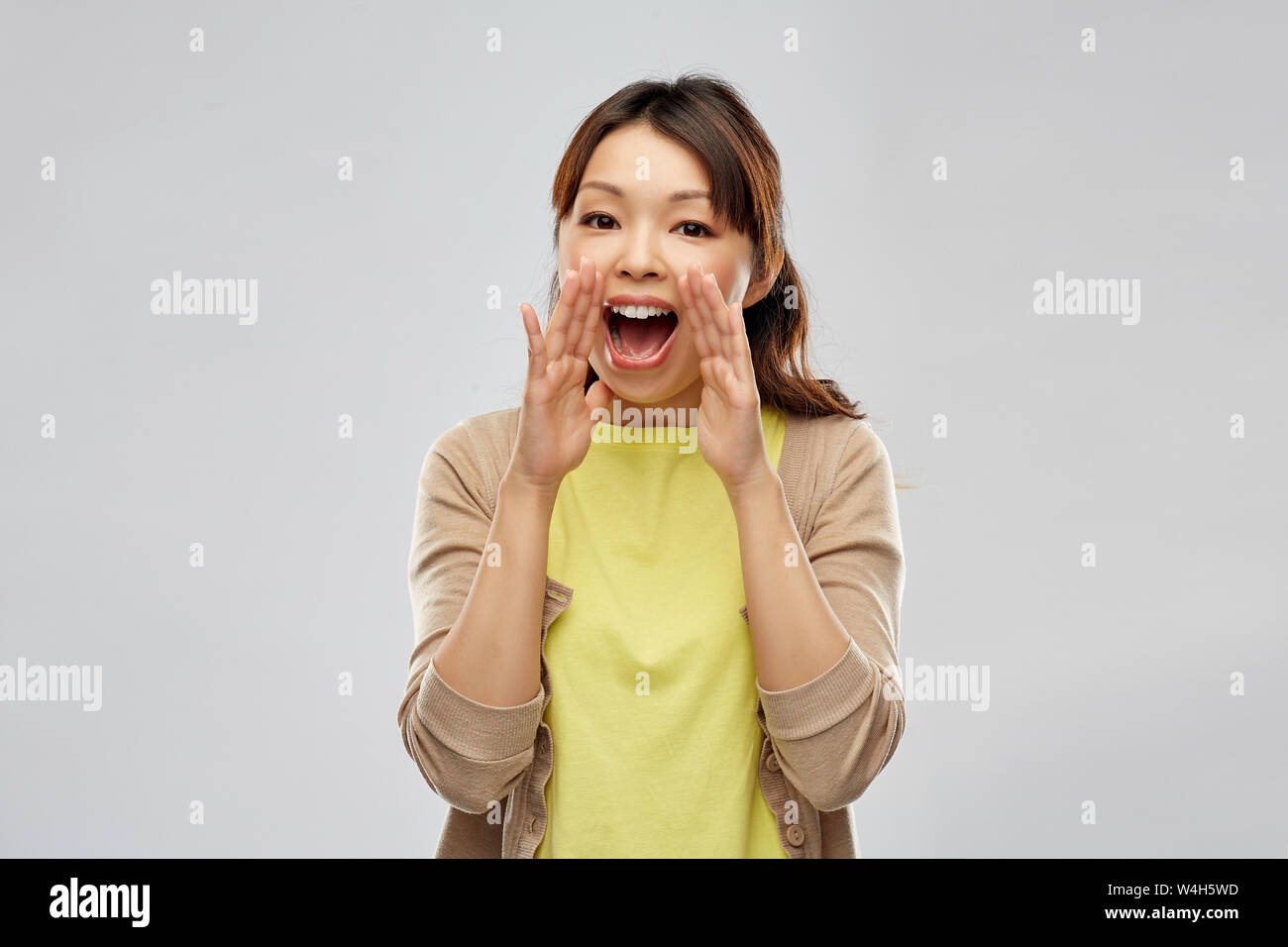 young asian woman calling for someone Stock Photo - Alamy