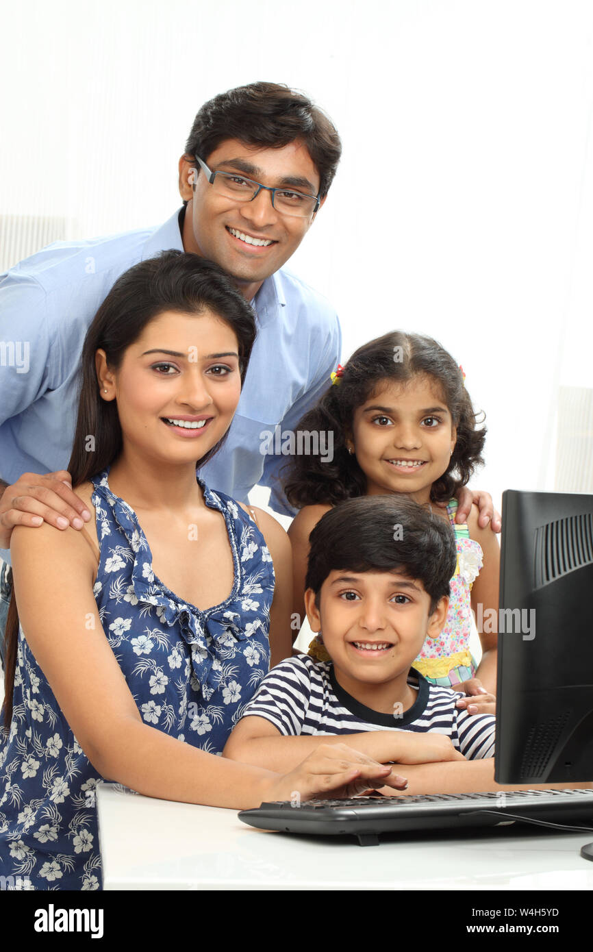Family working on a computer and smiling Stock Photo - Alamy
