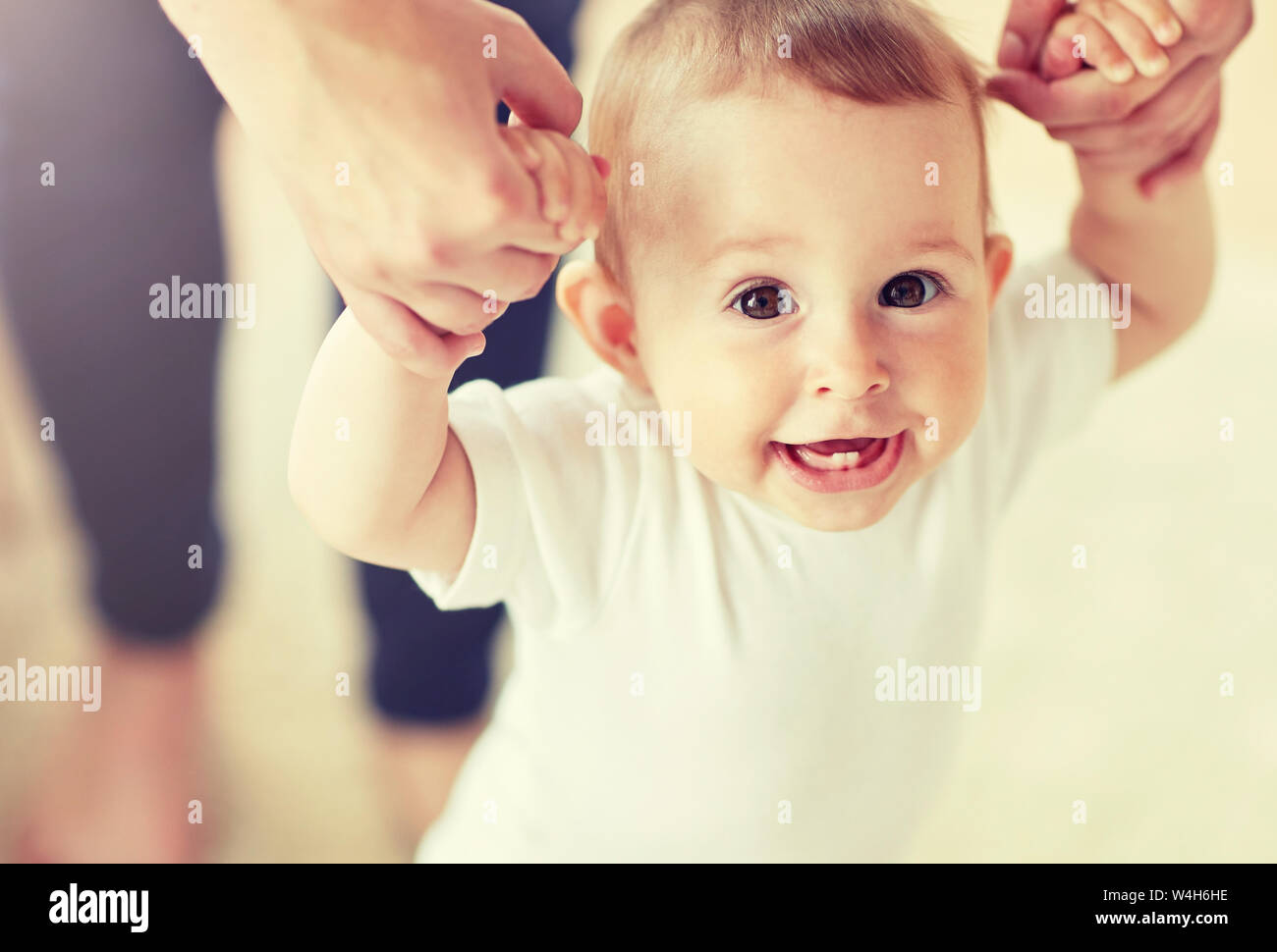 happy baby learning to walk with mother help Stock Photo - Alamy