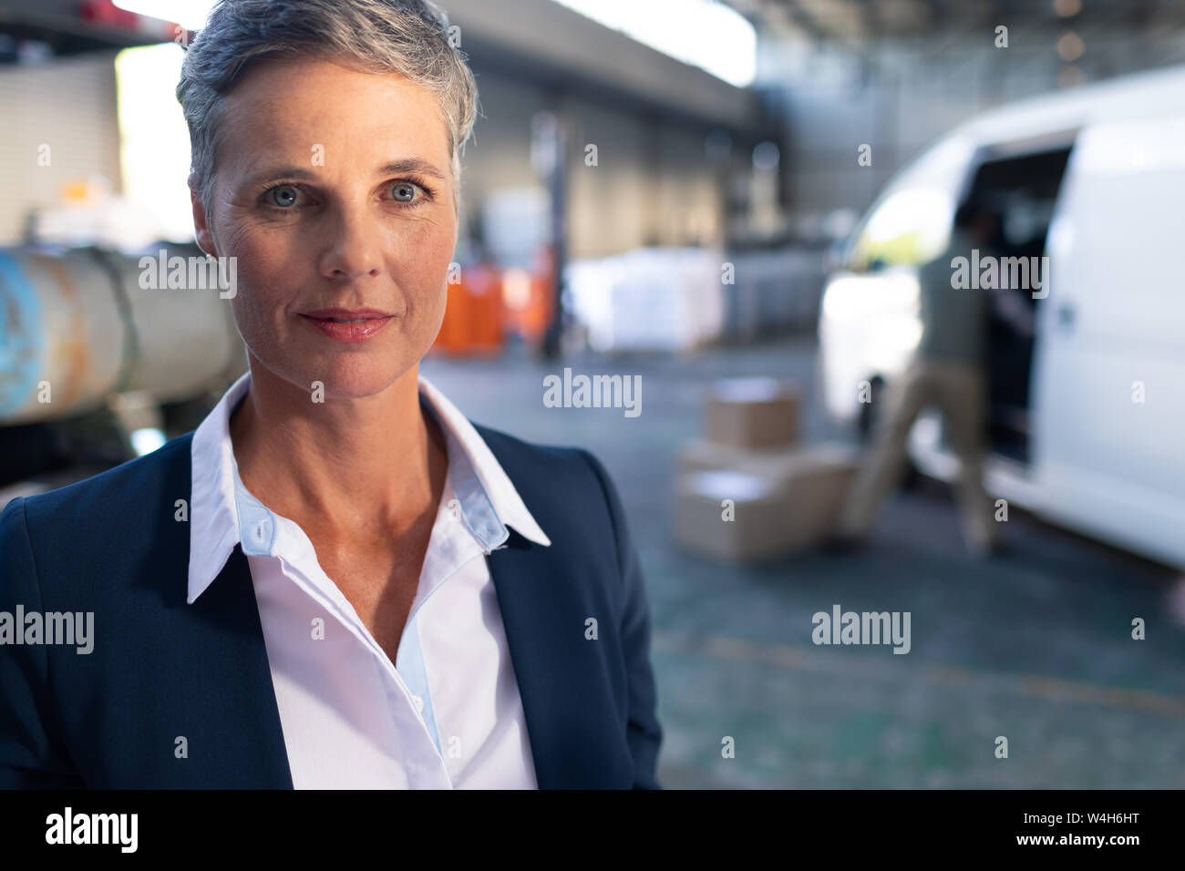 Happy female manager looking at camera in warehouse Stock Photo - Alamy
