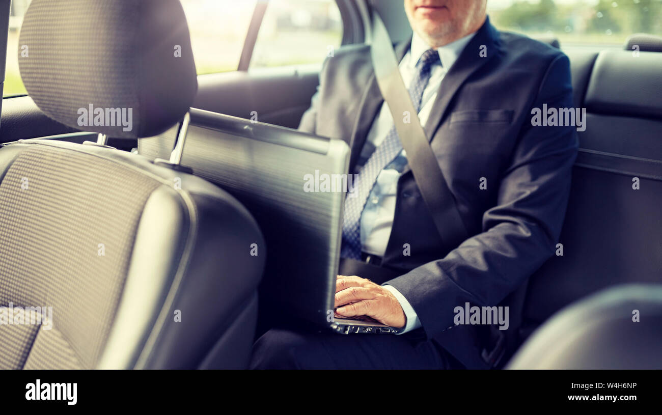 senior businessman with laptop driving in car Stock Photo - Alamy