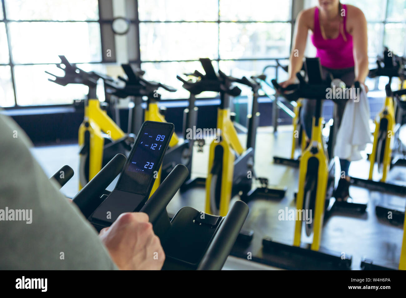Male athletic checking speed on screen of exercise bike in fitness ...